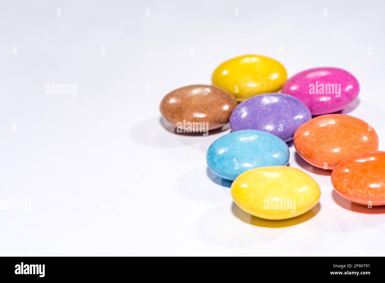 Colorful dragees, close-up on a white background. Chocolate candies in ...