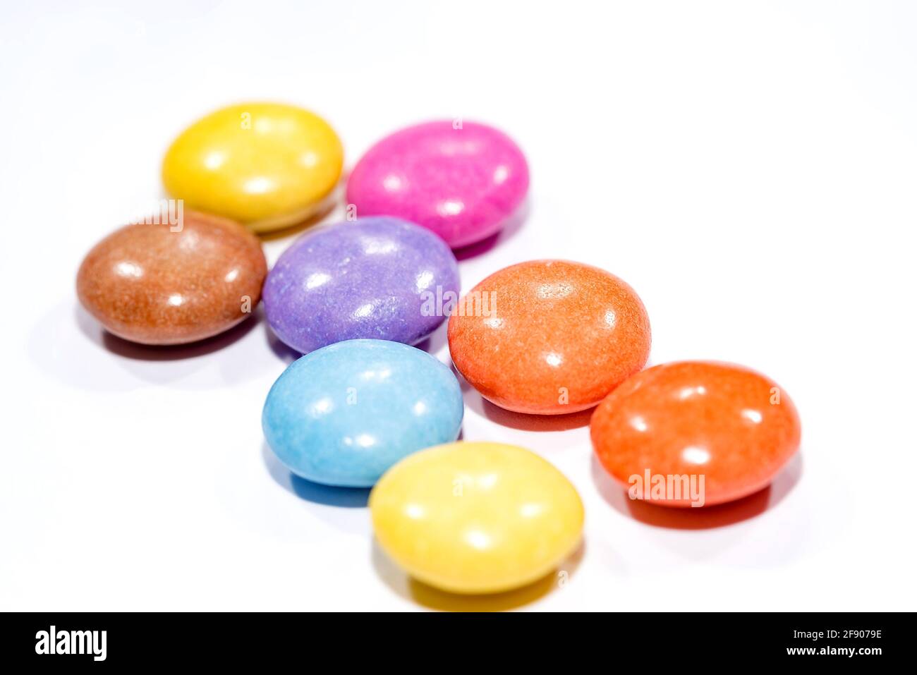 Colorful dragees, close-up on a white background. Chocolate candies in ...