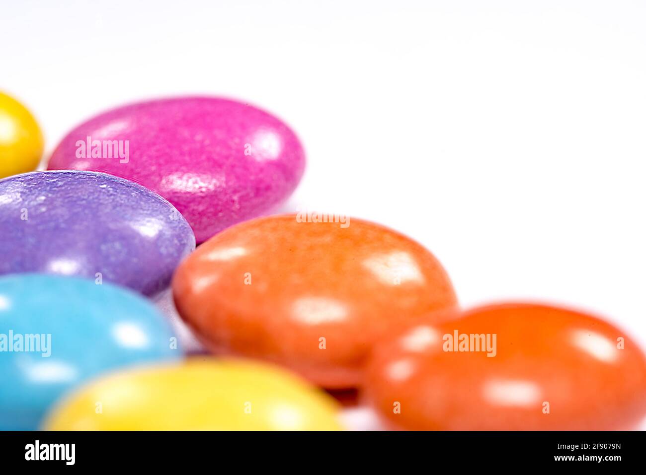 Colorful dragees, close-up on a white background. Chocolate candies in ...