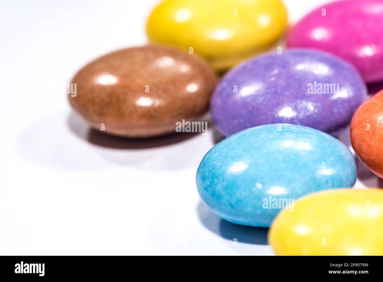 Colorful dragees, close-up on a white background. Chocolate candies in ...