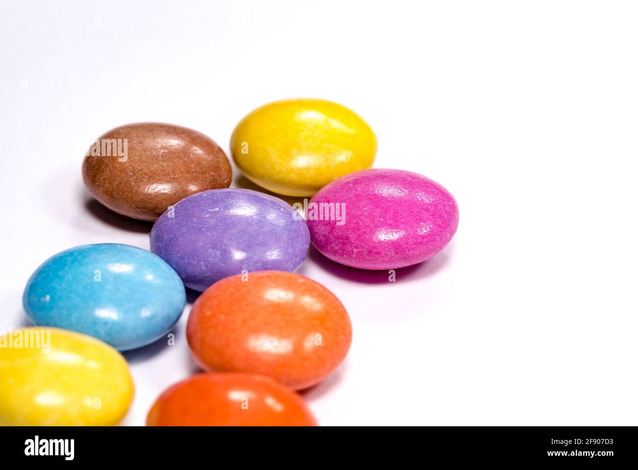Colorful dragees, close-up on a white background. Chocolate candies in ...