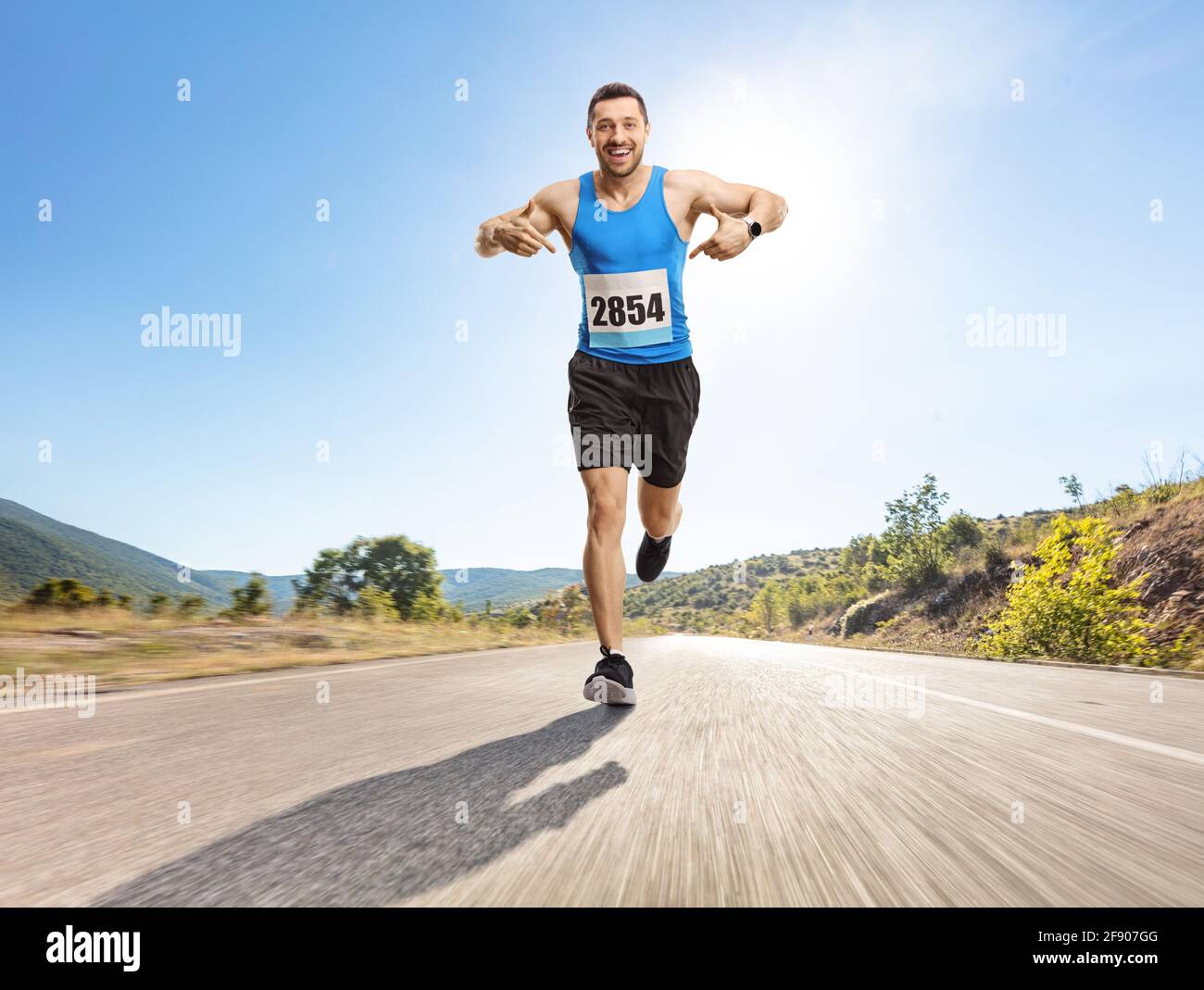 Full length portrait of a fit young man running a marathon on an open ...