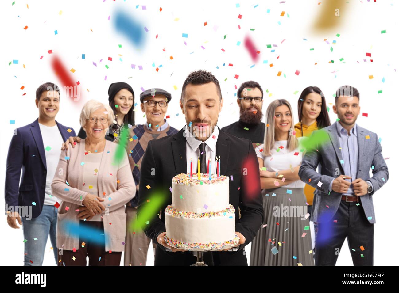 People at a birthday party and a man holding a cake isolated on white ...