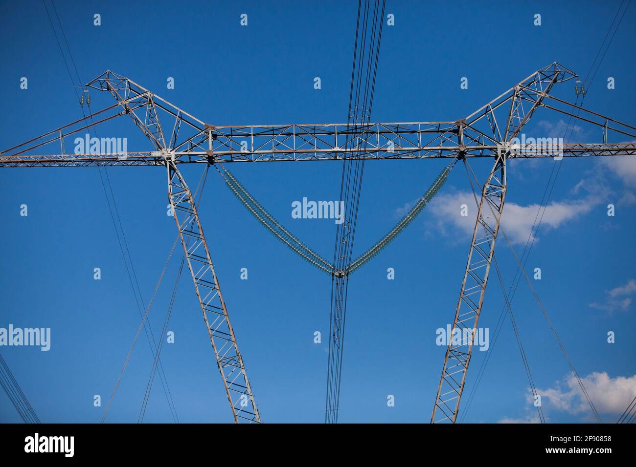 Electric pylon (pole) and glass insulators on blue sky with light ...