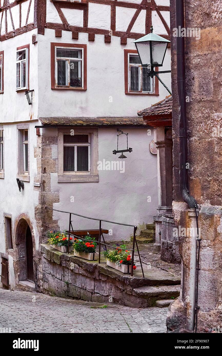 Medieval street corner with stone archway and half-timbered houses in ...
