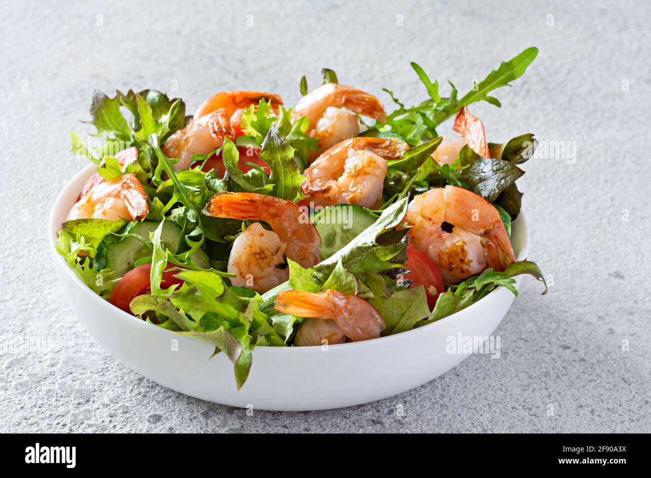 Fresh crispy salad with vegetables and seafood (shrimps) in a white ...