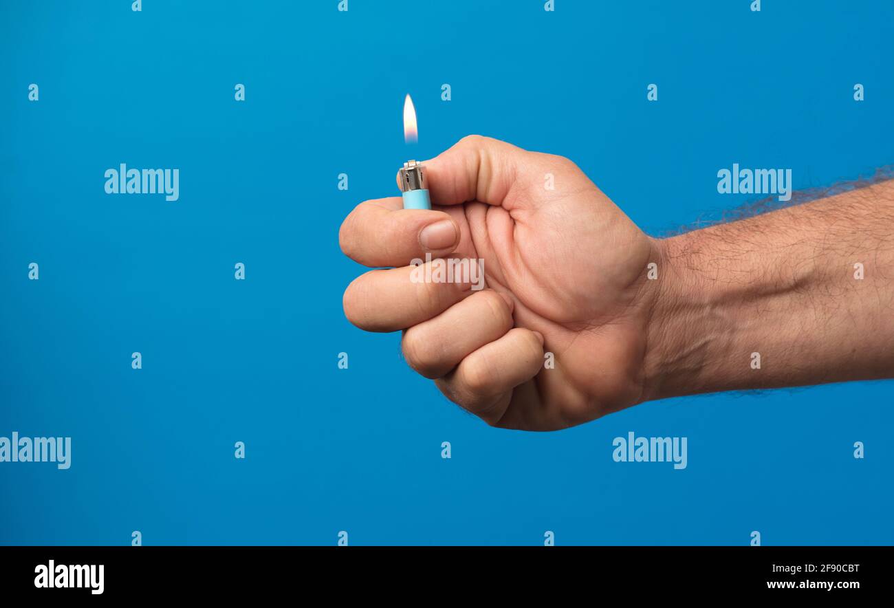 man hand with lighter with fire flame Stock Photo - Alamy