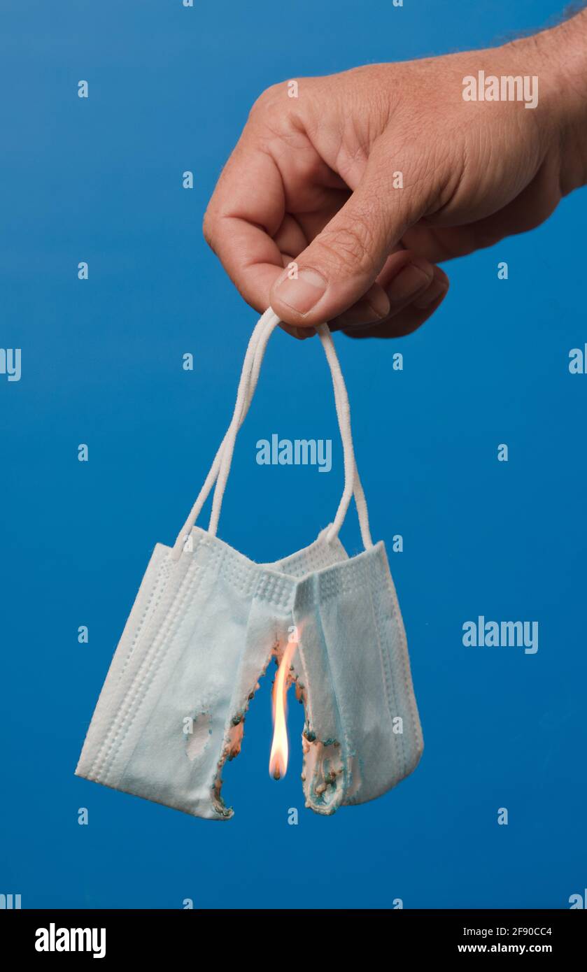 hand with surgical facial mask burning, with blue background Stock ...