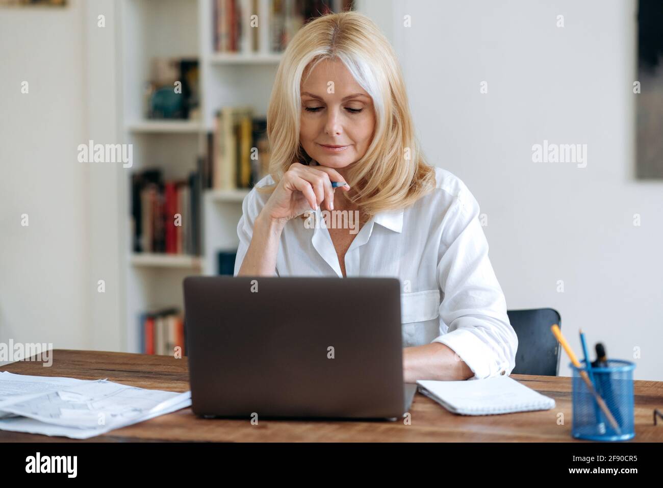 Concentrated woman freelancer uses laptop hi-res stock photography and ...