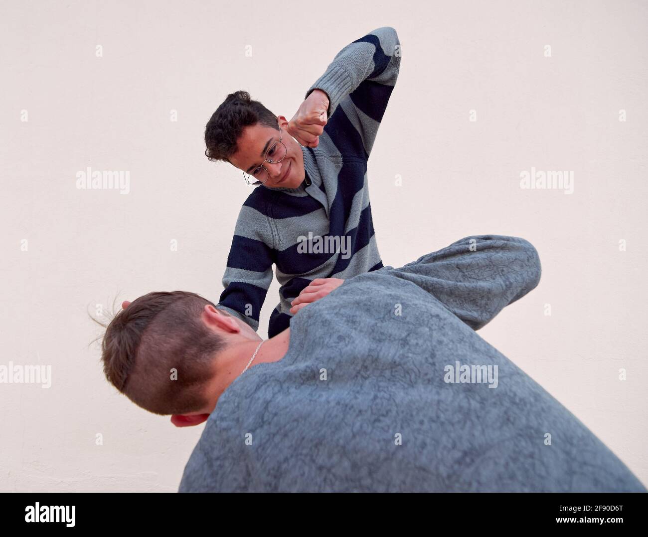 Young male bully aggressively punching another scared male Stock Photo ...