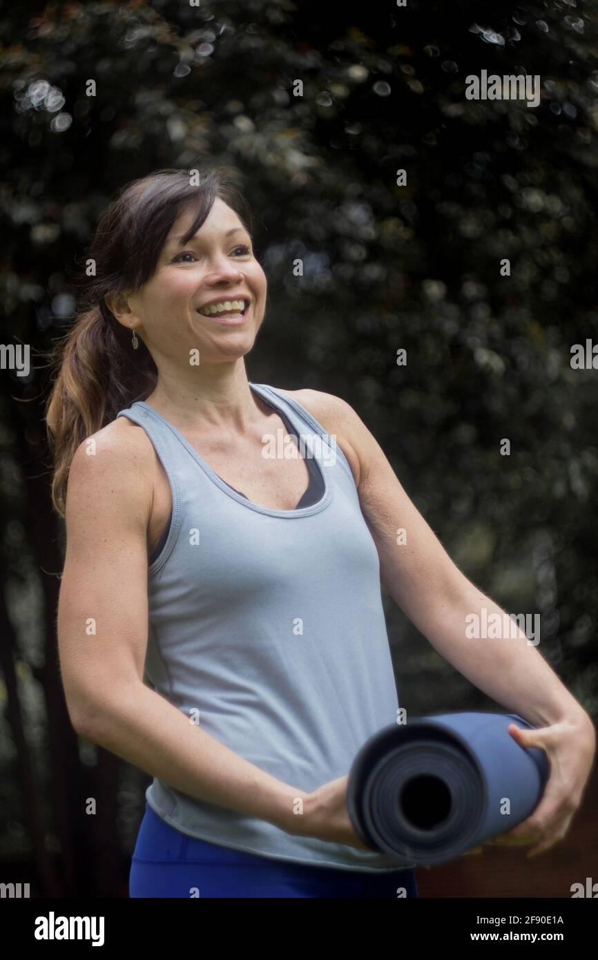 Closeup of an energetic Colombian woman holding a yoga mat Stock Photo ...