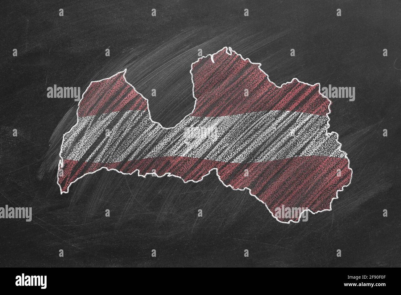Country map and flag of Latvia drawing with chalk on a blackboard. One ...