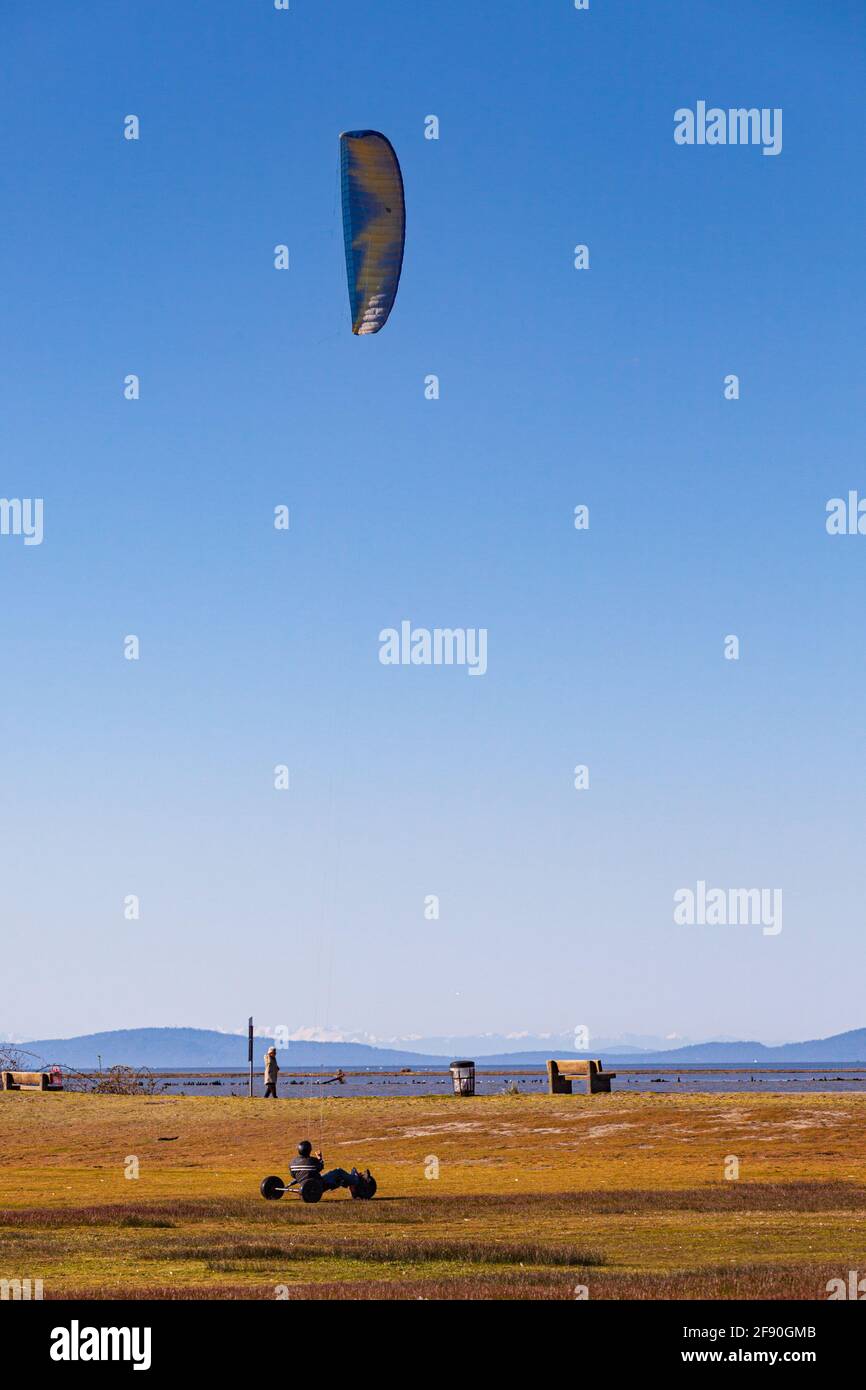 Wind powered three-wheeled cart speeding over grassy terrain in ...