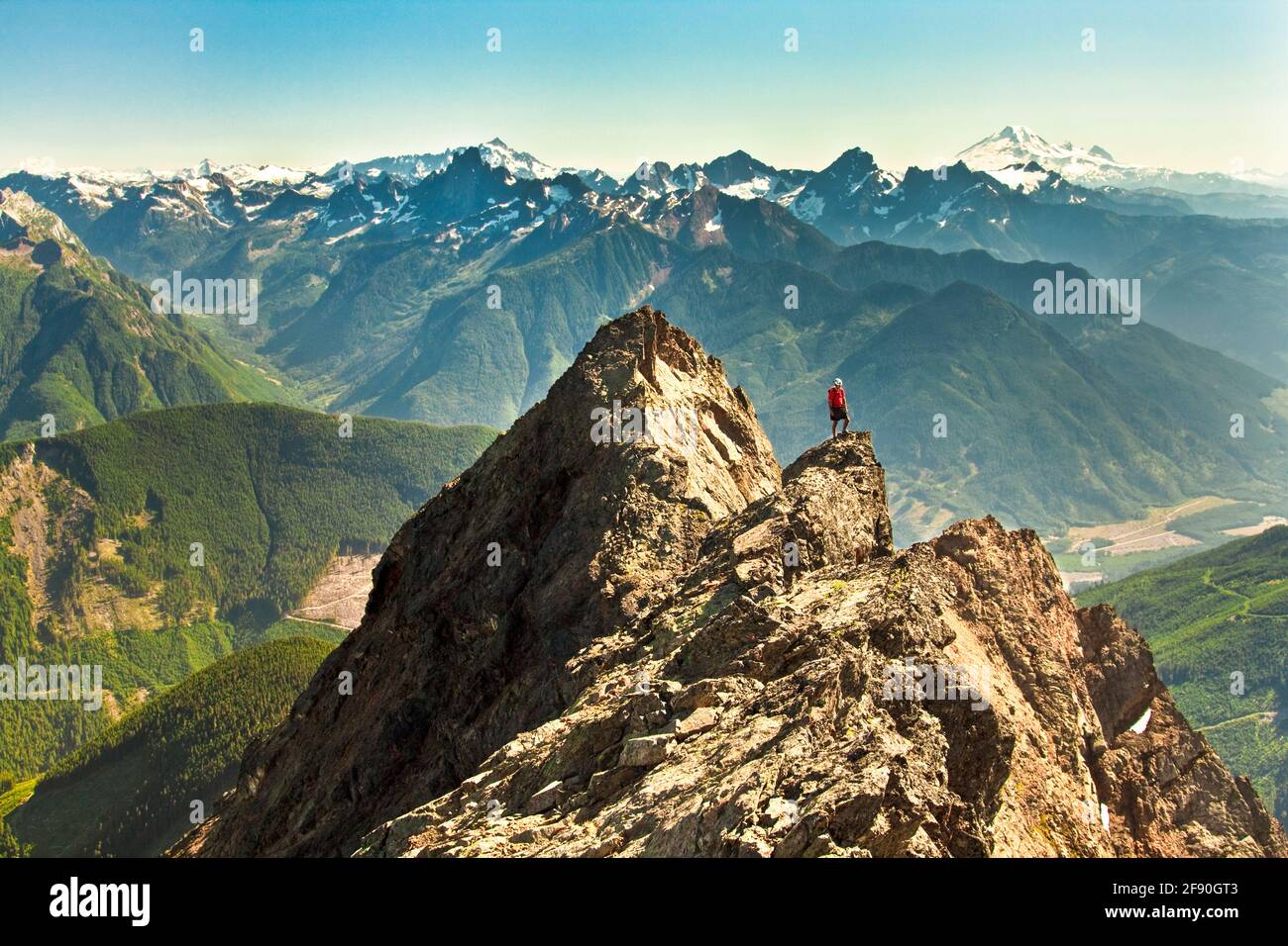 Mountain climber stands on mountain summit in British Columbia, Canada ...