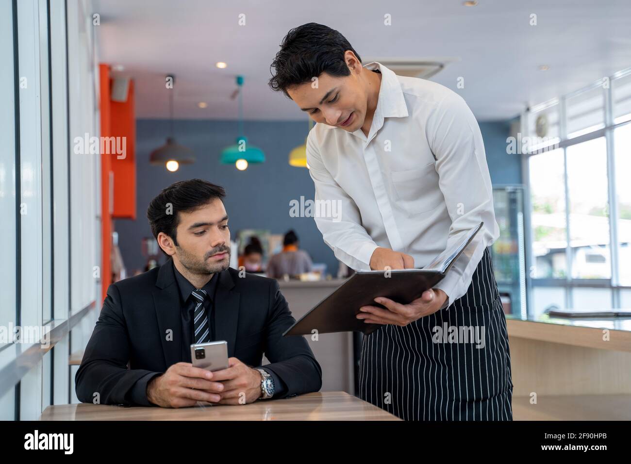 Person ordering food at restaurant hi-res stock photography and images ...