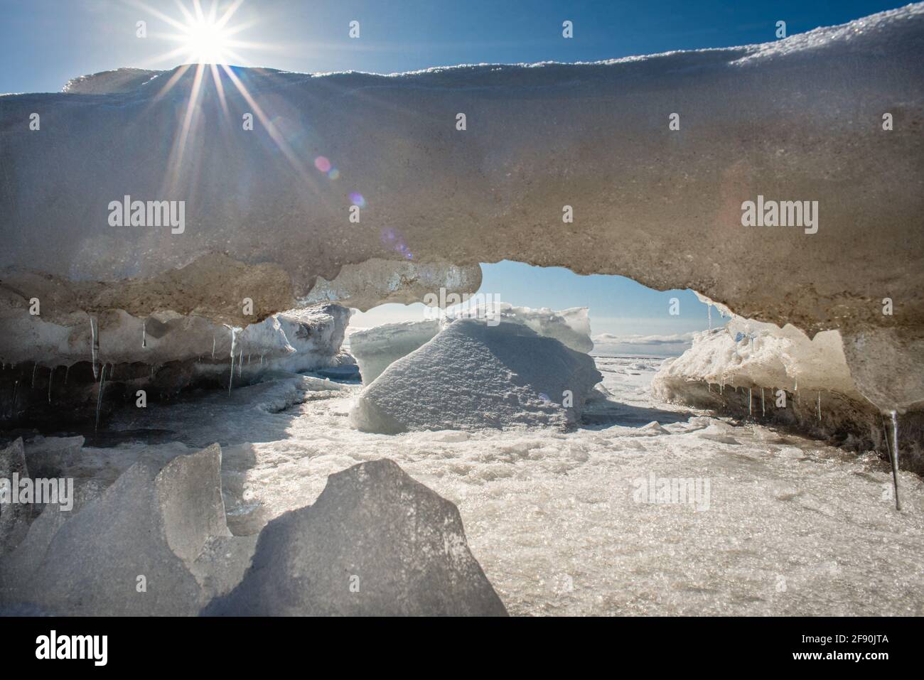 Ice formations melting along shoreline of a lake on bright sunny day ...