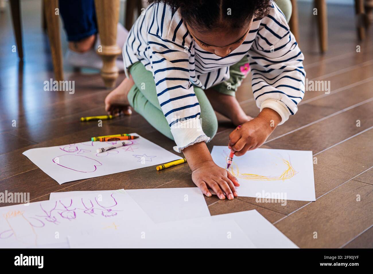 Girl drawing with crayons on paper at home Stock Photo - Alamy