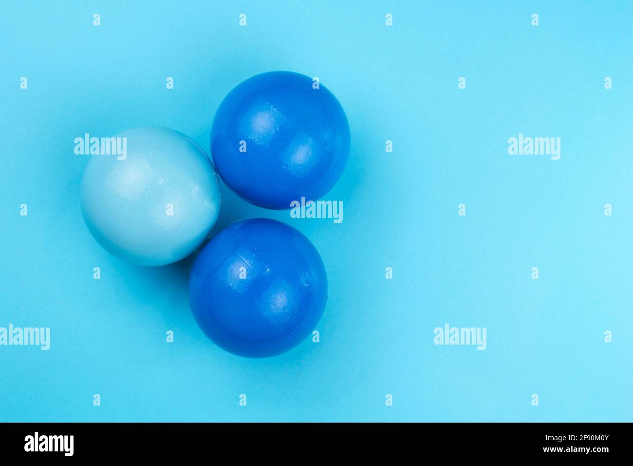 three balls in different shades of plastic on a blue background Stock ...