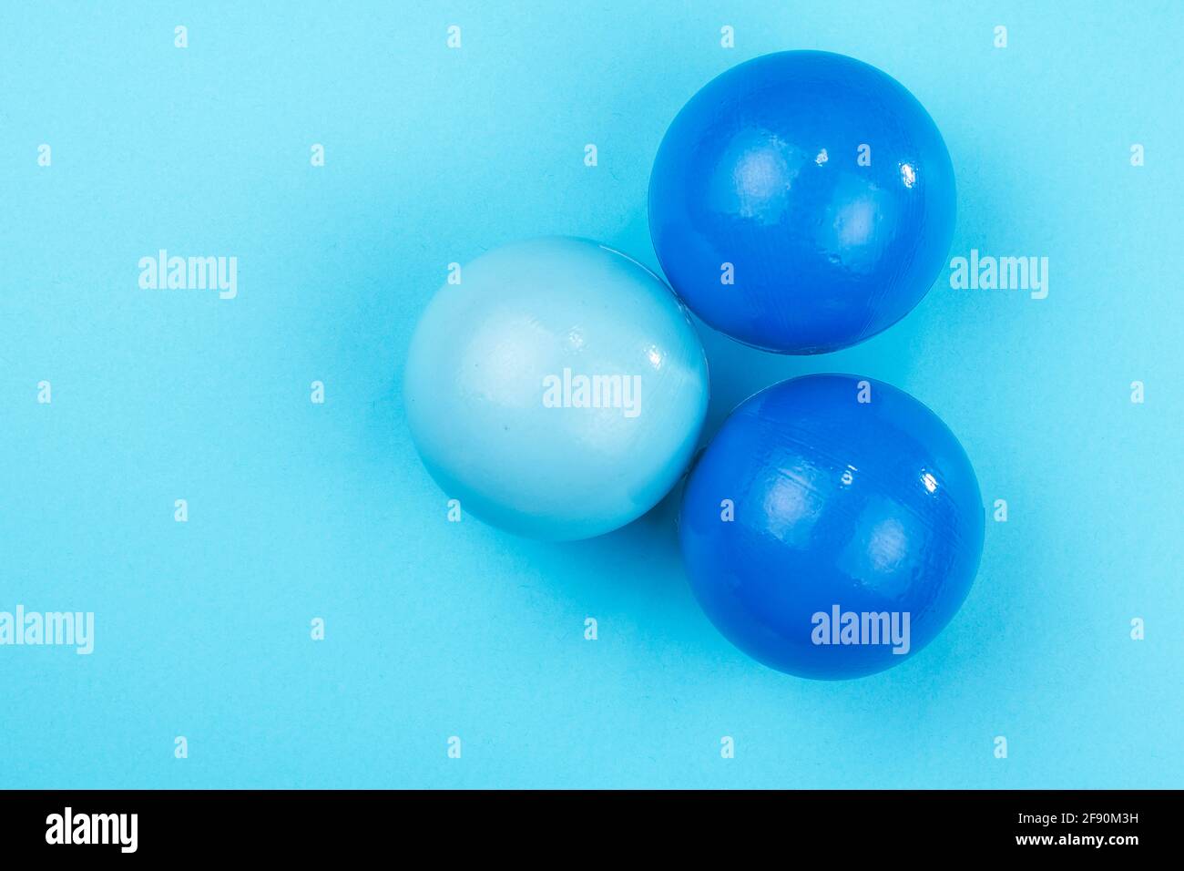 three balls in different shades of plastic on a blue background Stock ...