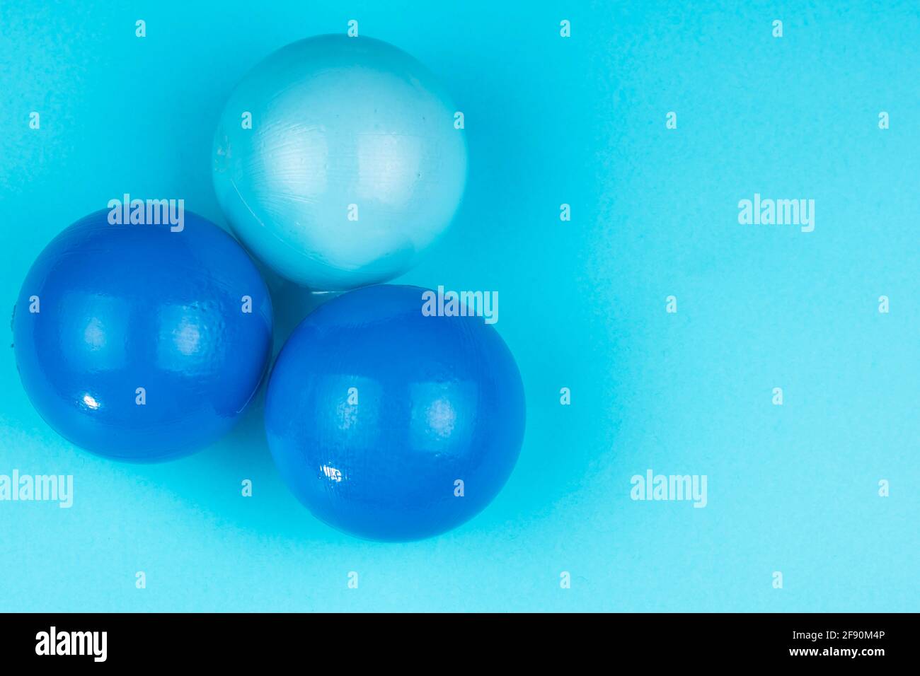 three balls in different shades of plastic on a blue background Stock ...