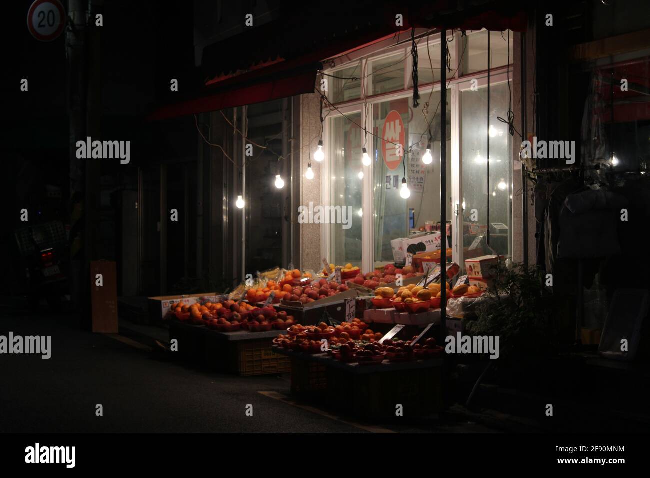 Night view of fruit market, lit by incandescent light bulbs, in ...