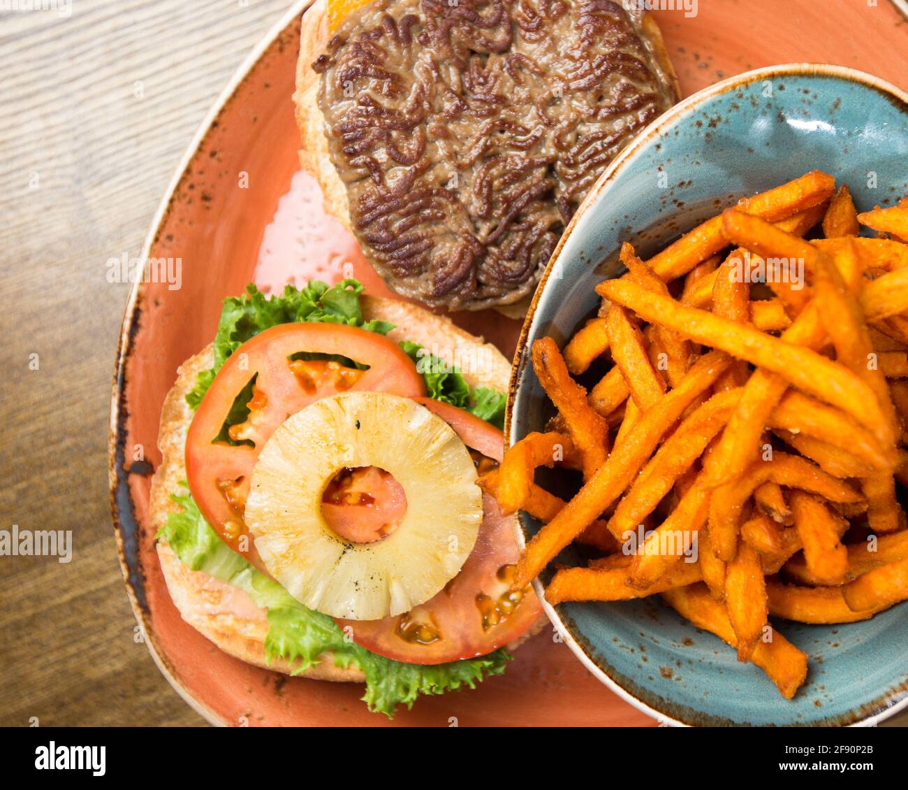 Top view of a gourmet fast food dish with an open burger and french ...