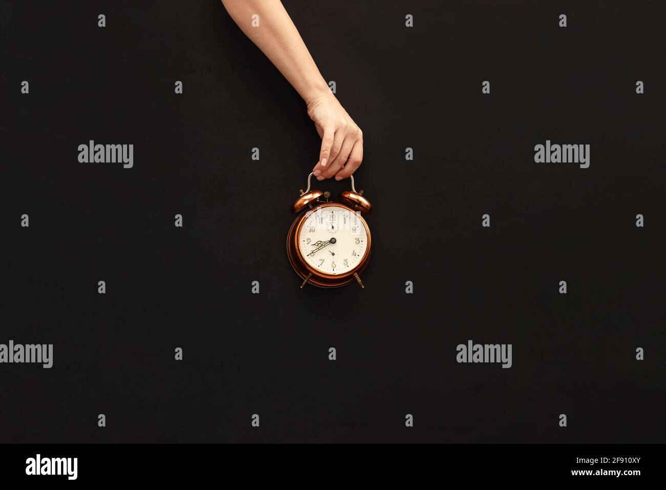 Hand holding bronze watch on black paper background Stock Photo - Alamy