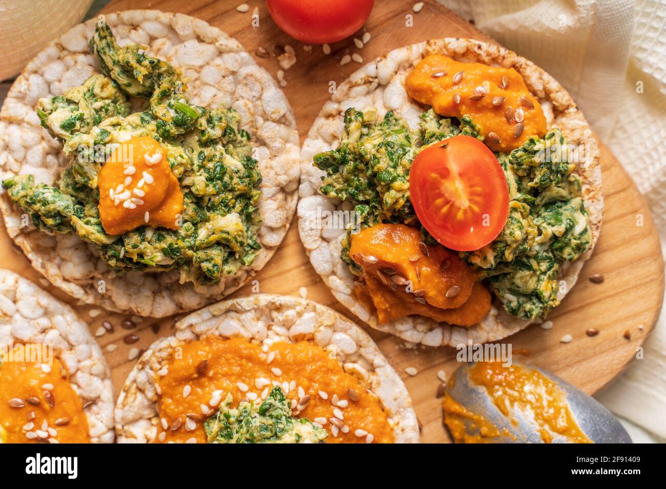 Crispy puffed rice cakes on table with hummus spread spinach with eggs ...