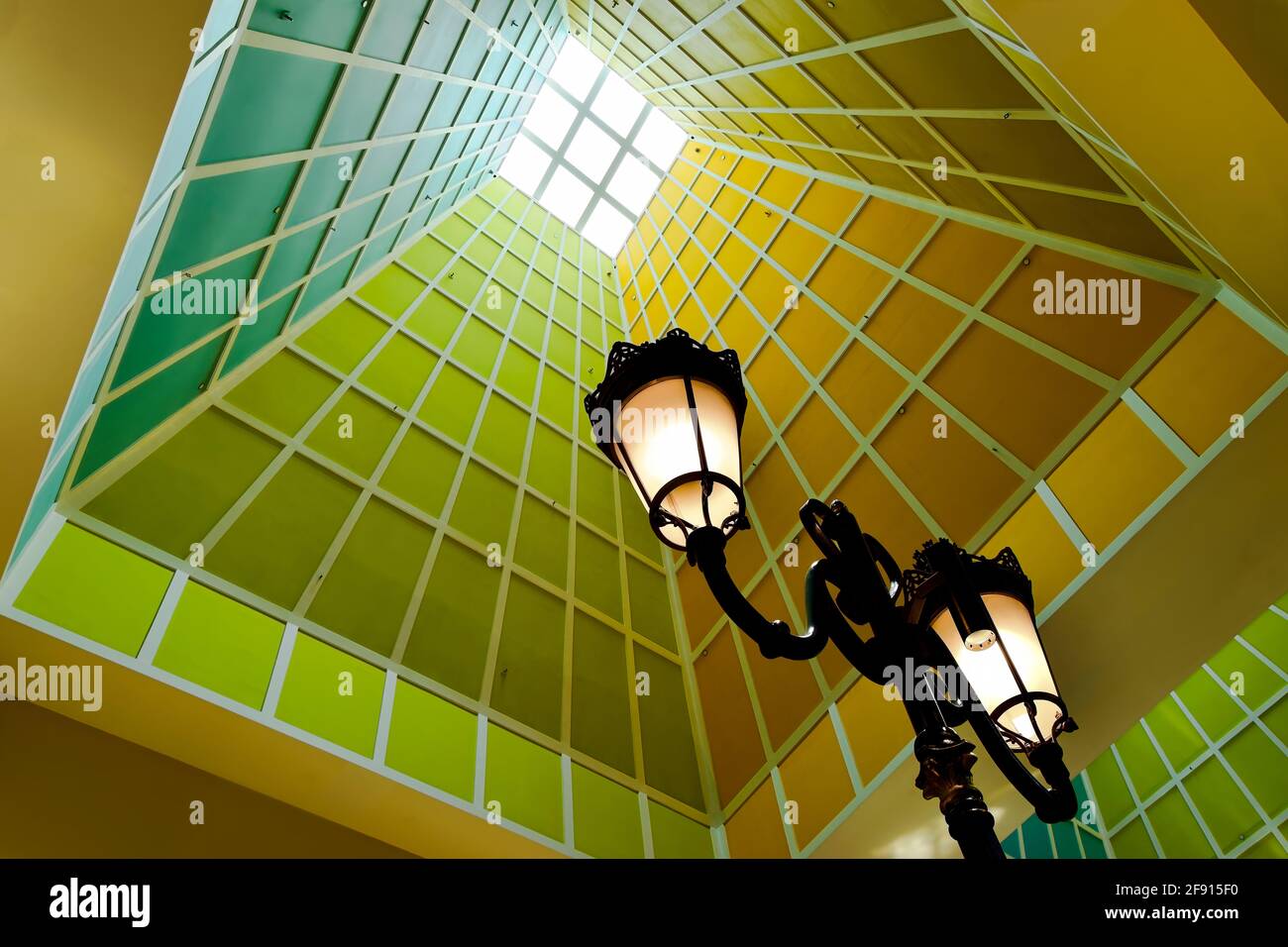 Sunlight through a vertical skylight on a geometric atrium tower with ...