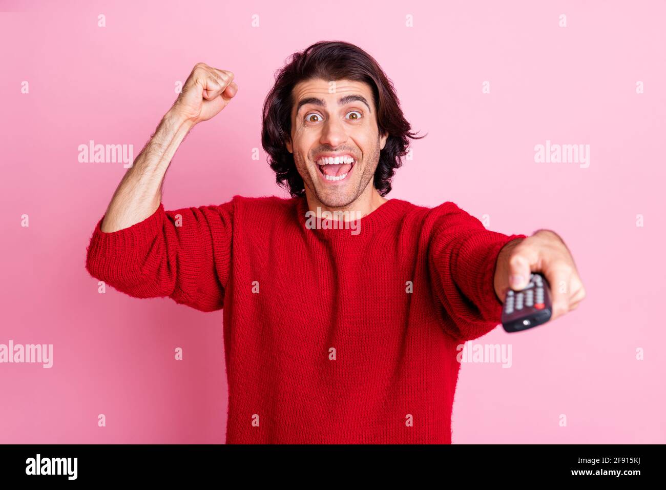 Photo portrait of cheerful guy holding tv remote control isolated on ...