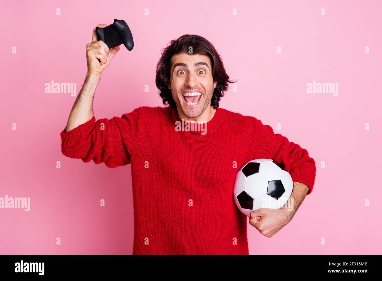 Photo portrait of excited guy holding football under arm gamepad in ...