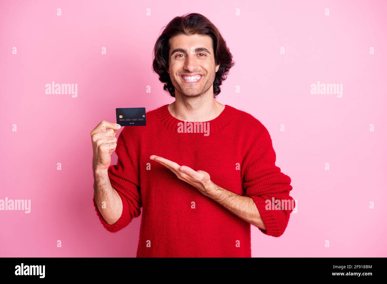 Photo portrait of man holding credit card in one hand presenting with ...