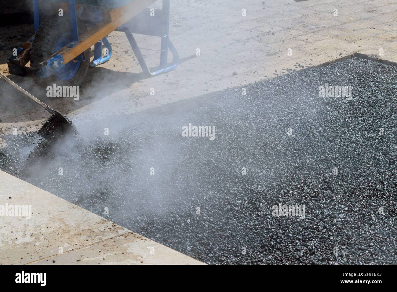 Road worker repair asphalt covering new road surface Stock Photo - Alamy