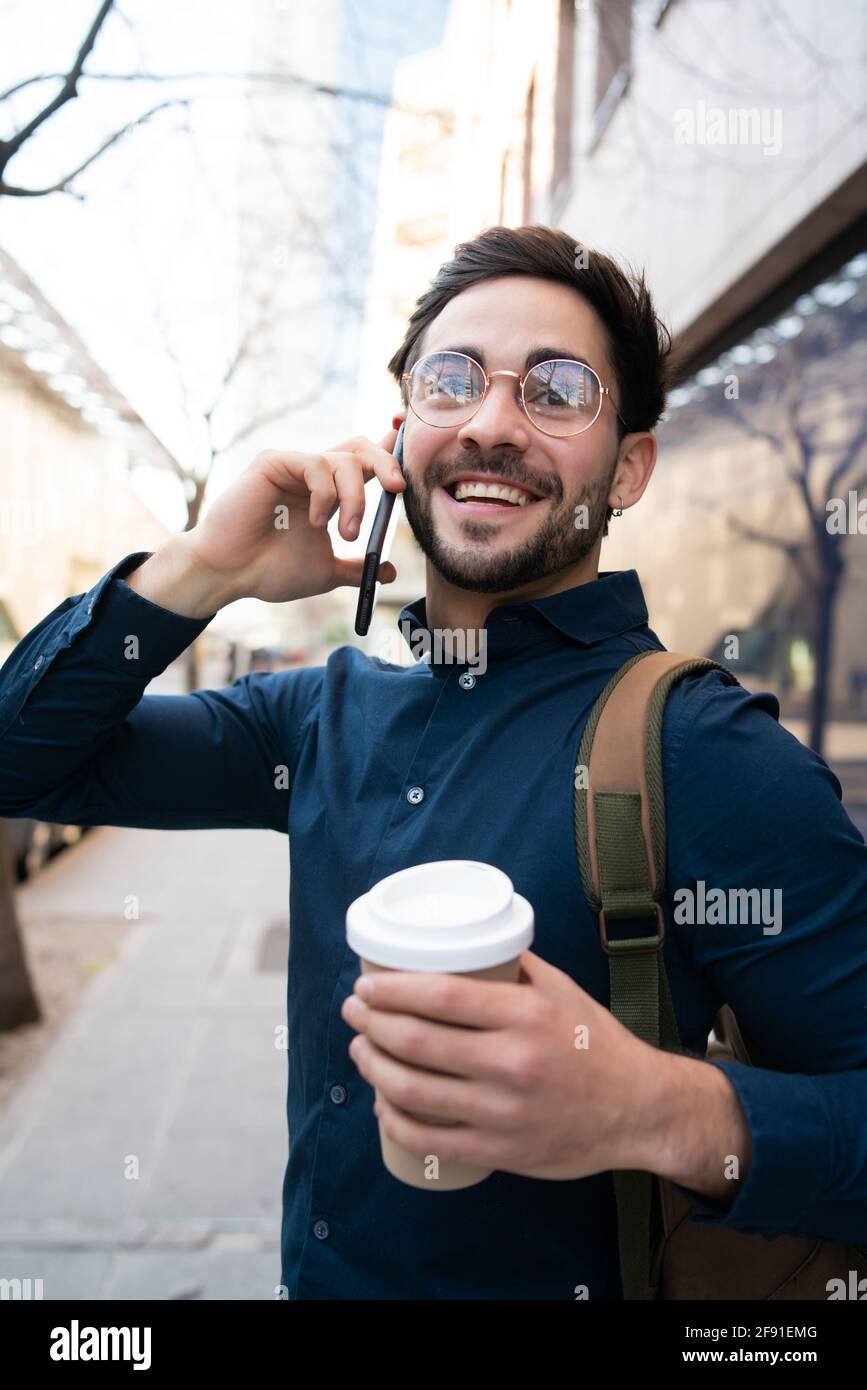 Young man talking cellphone drinking hi-res stock photography and ...