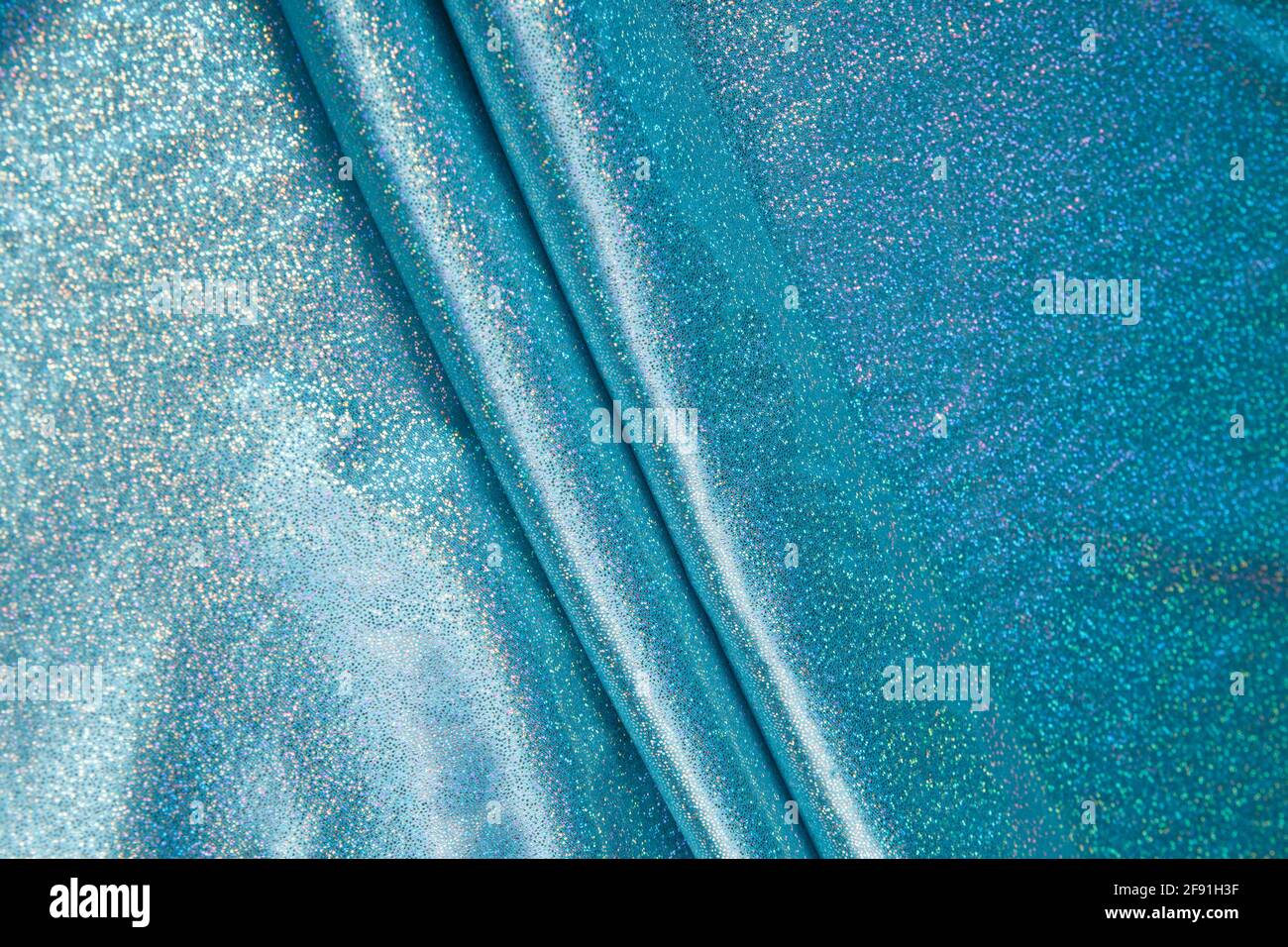Colored blue textile satin fabric folded in folds and waves with ...