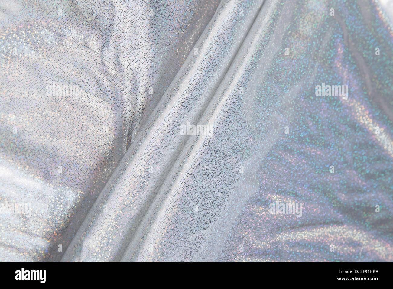 Colored silver textile satin fabric folded in folds and waves with ...