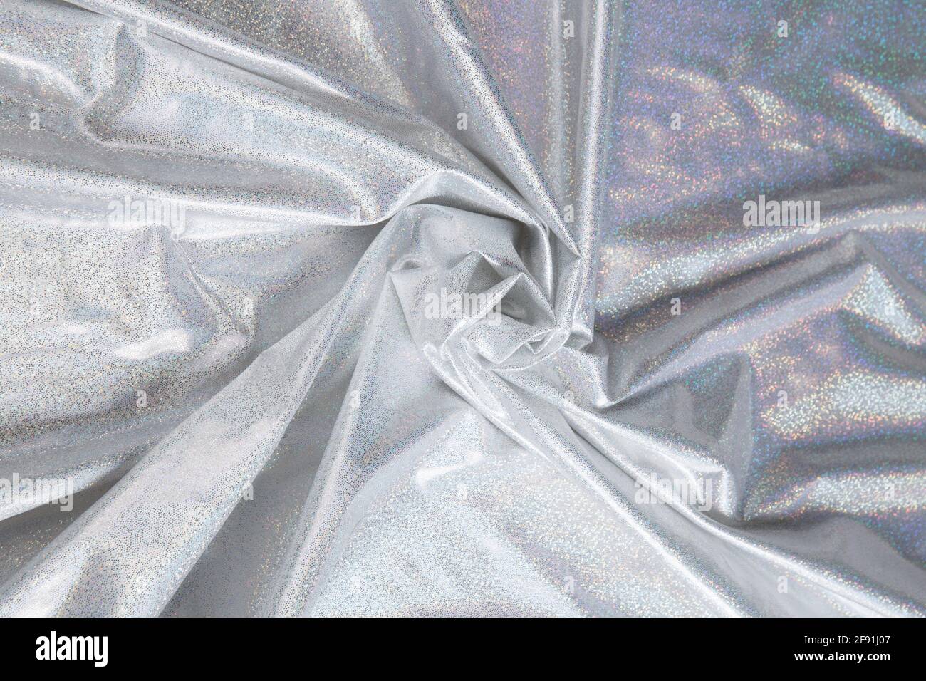 Colored silver textile satin fabric folded in folds and waves with ...