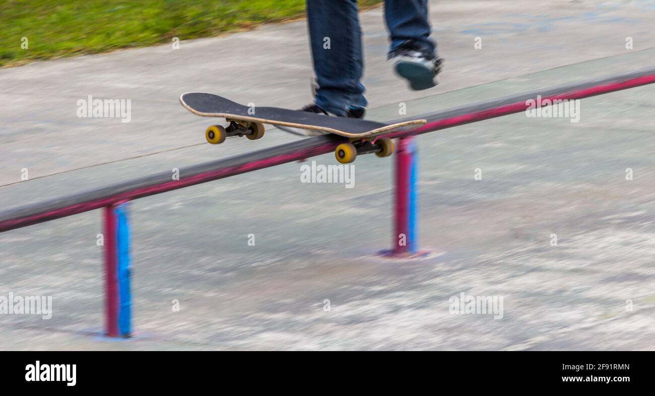 Professional skater doing a trick on a metal fence with a skateboard ...