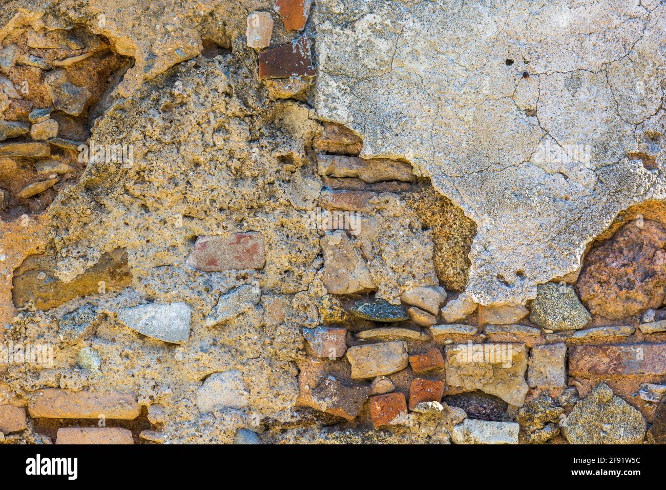 Old semi-destroyed stone wall textured background made of different ...