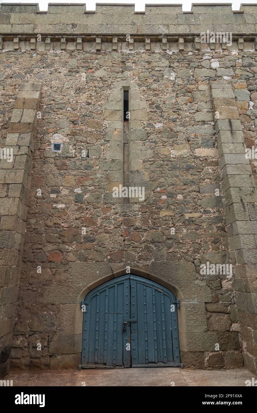 Ancient stone wall with a gate in the old castle. Wooden gate of a ...