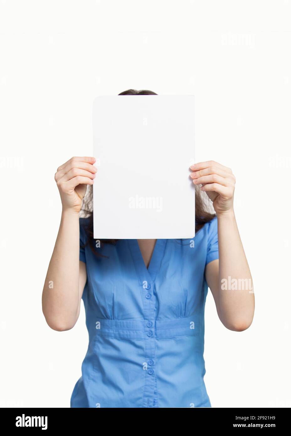 Elegant slender girl in blue dress holds white sheet of paper in hands ...