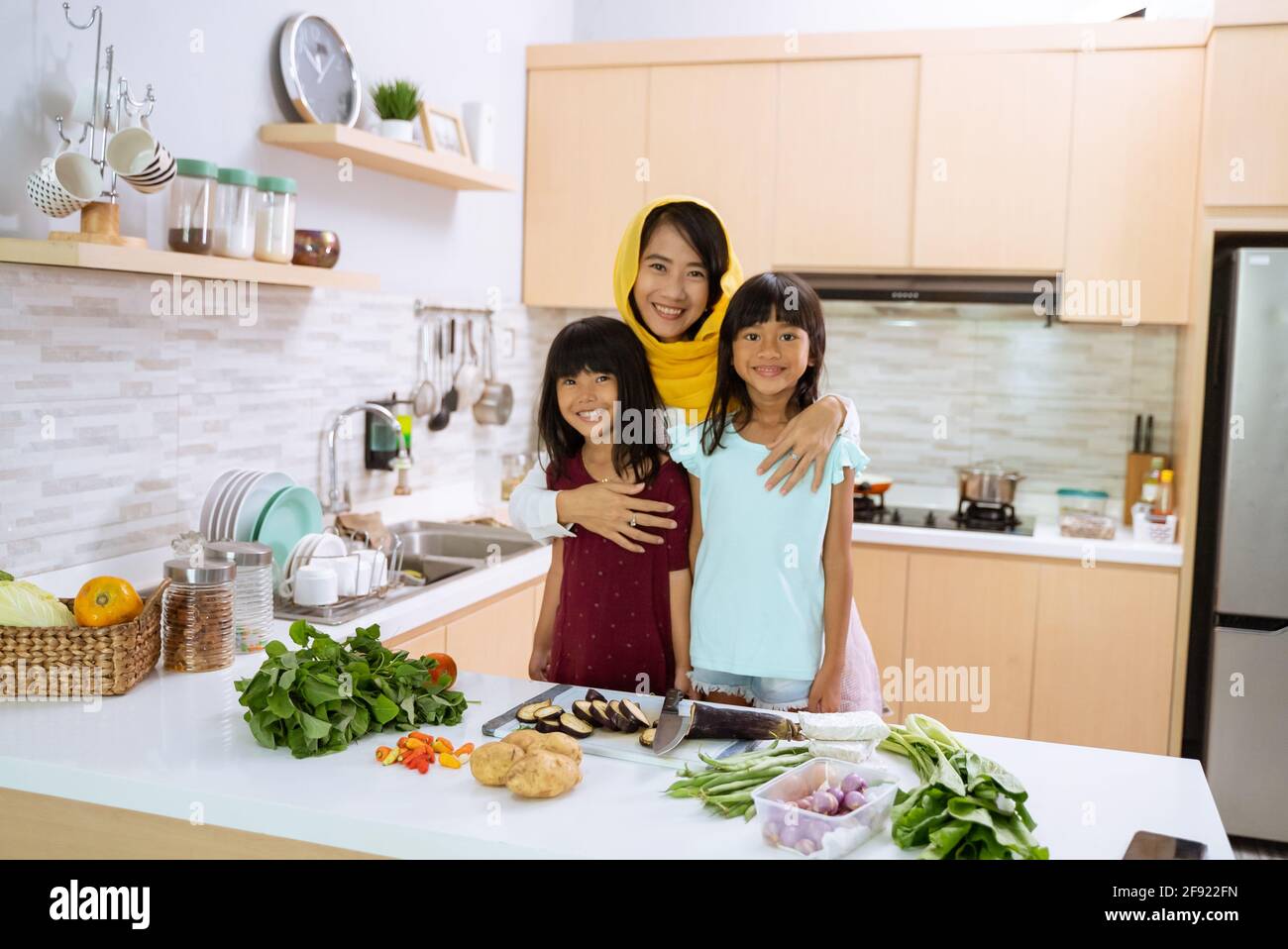 muslim mother with her two lovely daughter cooking in the kitchen Stock ...