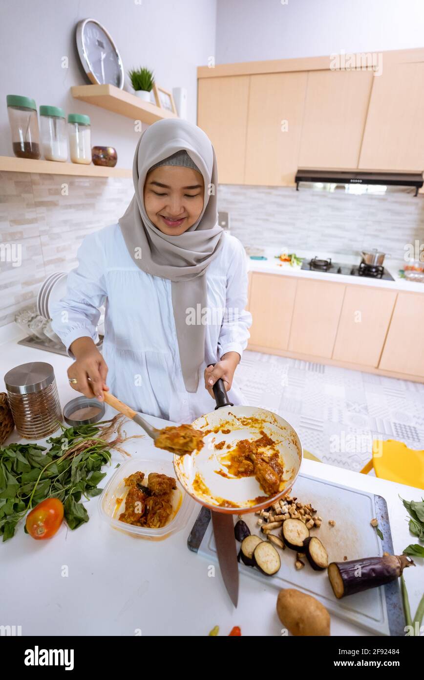 Hijab woman cooking home hi-res stock photography and images - Alamy