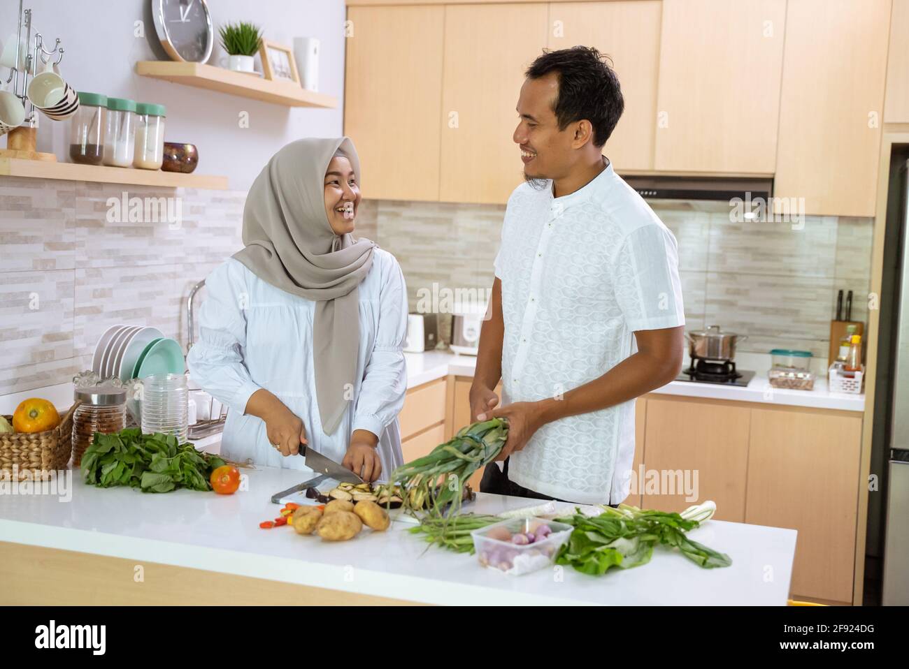 husband help his wife cooking together in the kitchen Stock Photo - Alamy