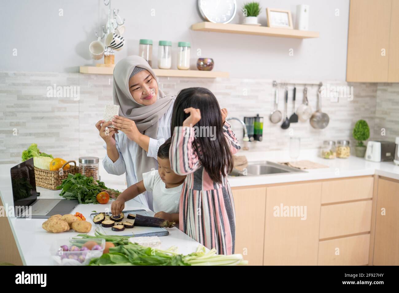 muslim mother and her children cooking together at home preparing for ...
