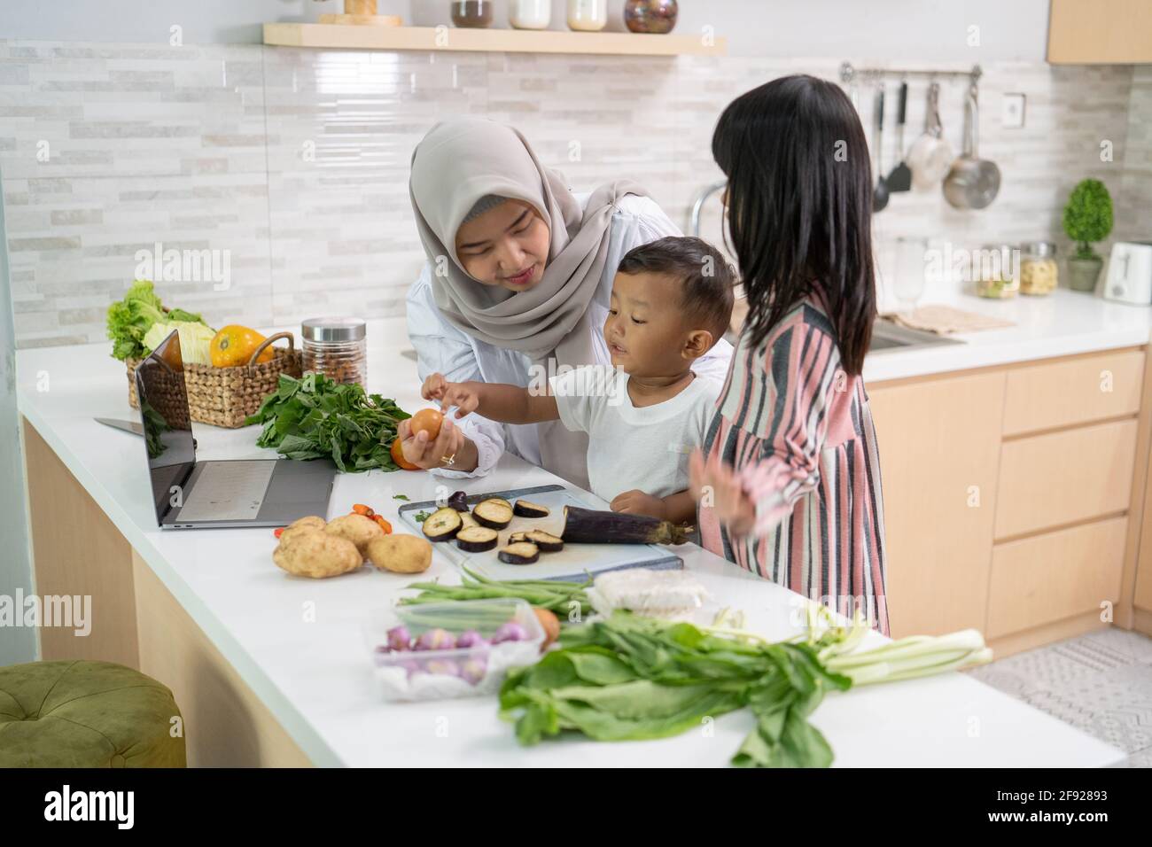 muslim mother and her children cooking together at home preparing for ...