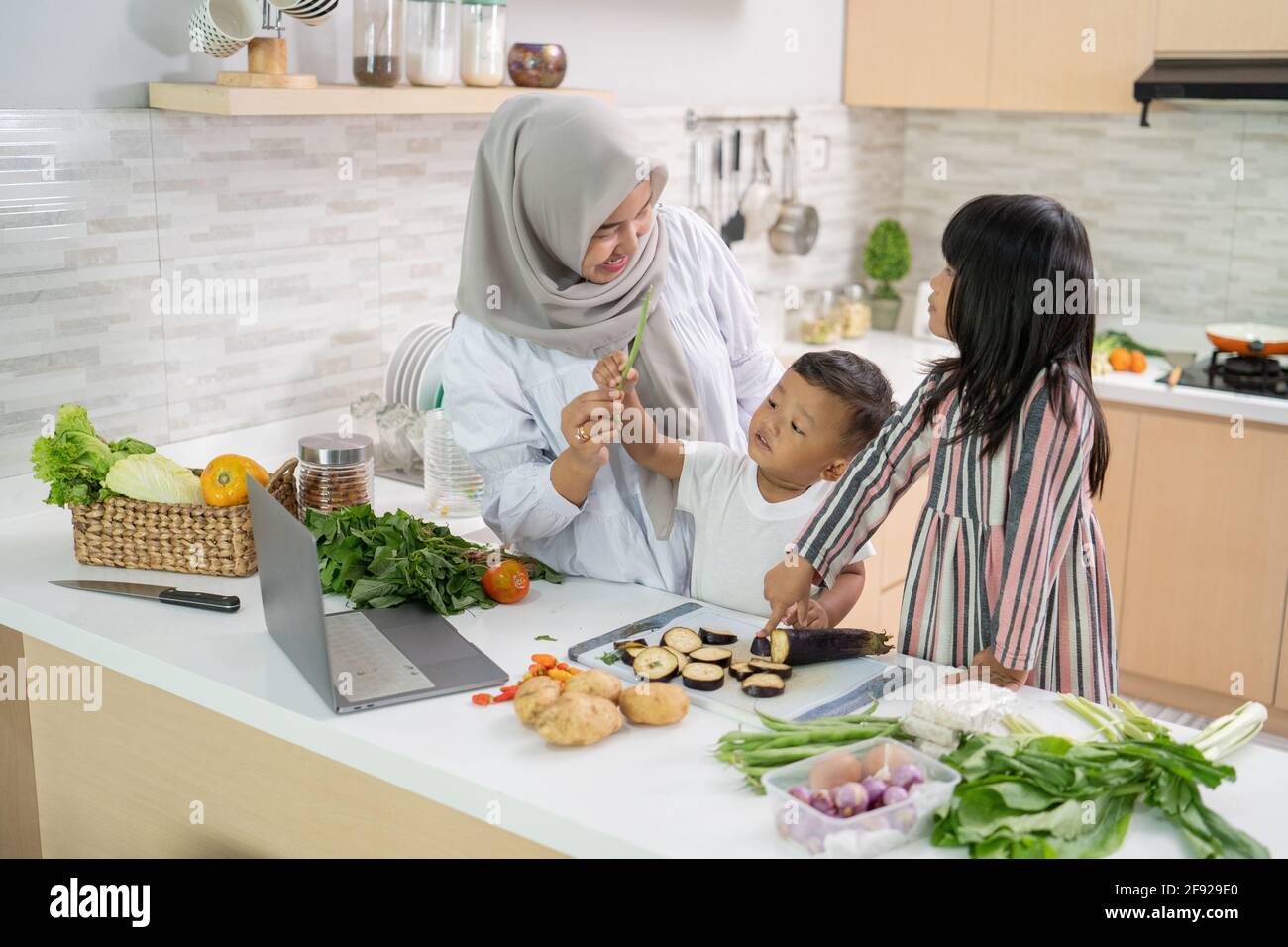 muslim mother and her children cooking together at home preparing for ...