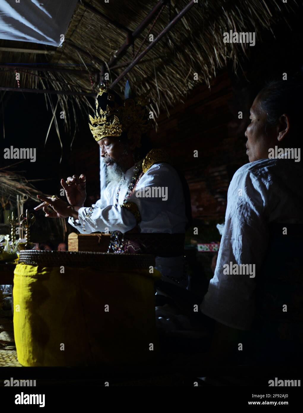 A Balinese Hindu priest conducting a spiritual ceremony during a temple ...