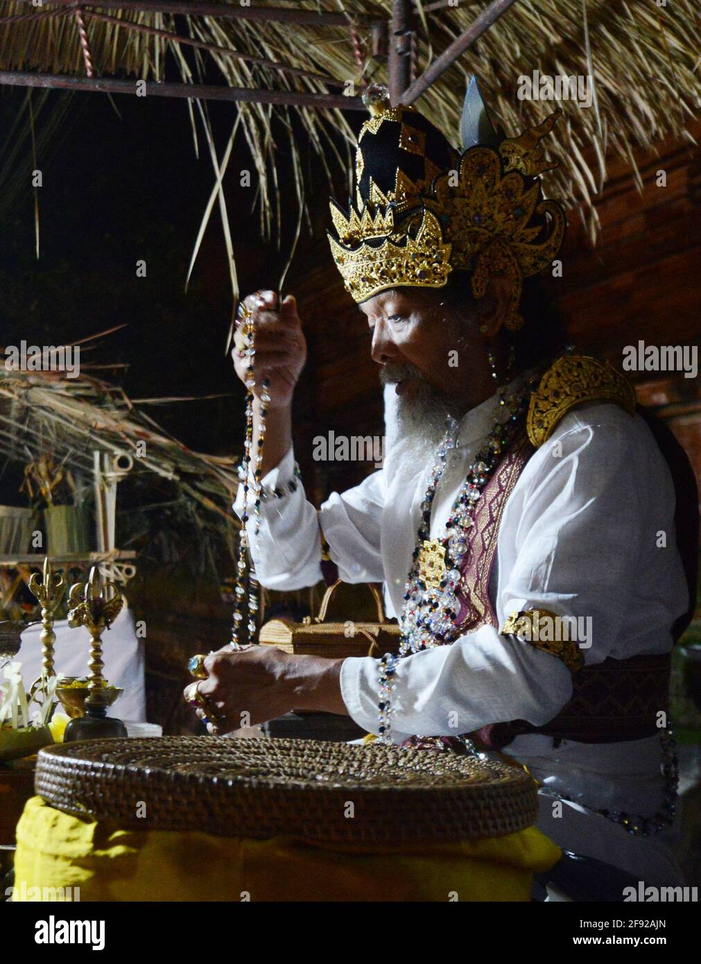 A Balinese Hindu priest conducting a spiritual ceremony during a temple ...