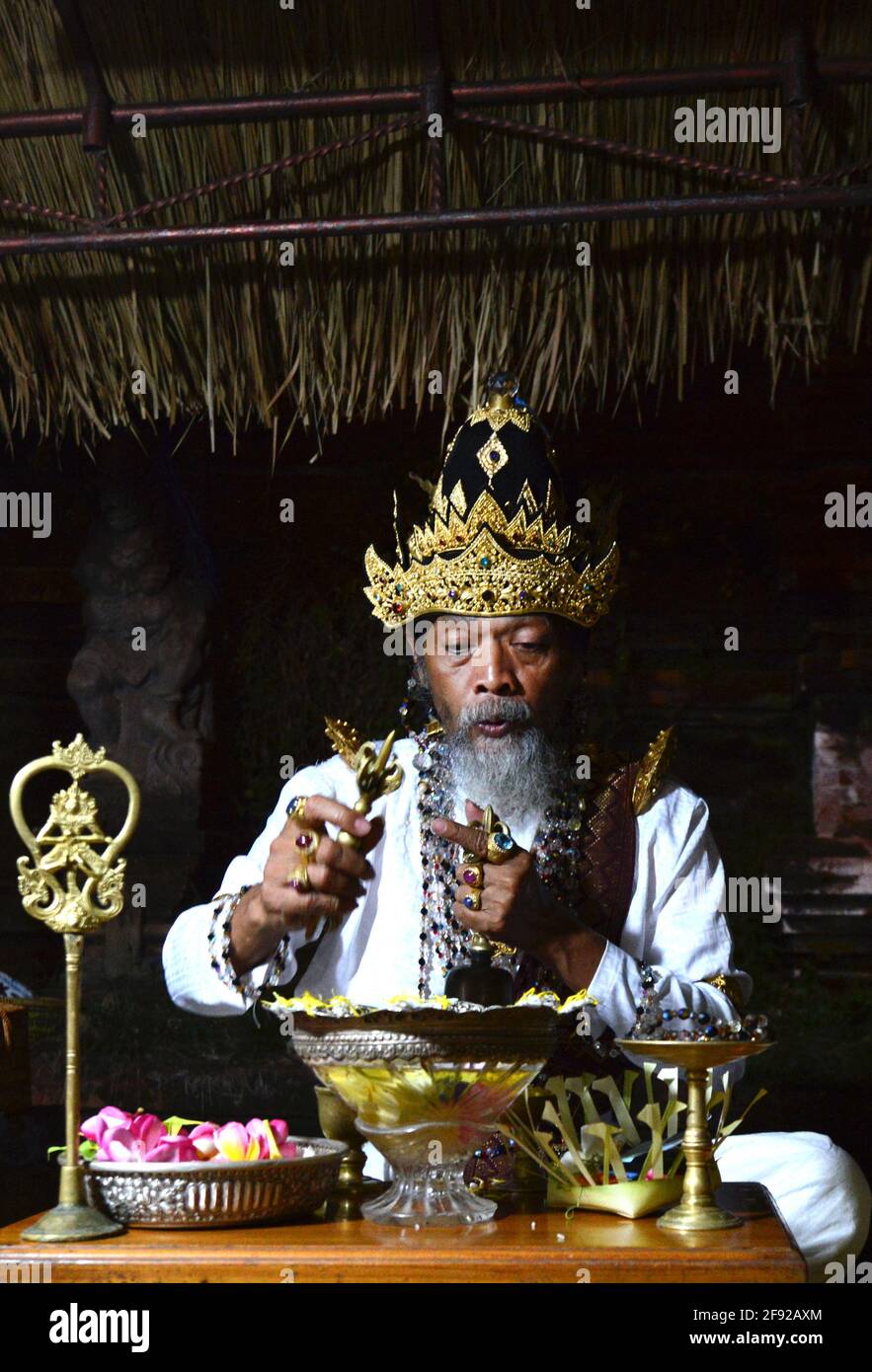 A Balinese Hindu priest conducting a spiritual ceremony during a temple ...